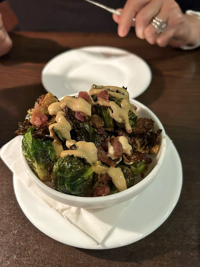 Brussels sprouts that could convert any vegetable skeptic. Roasted to caramelized perfection with bacon bits and a drizzle of creamy sauce that ties it all together.