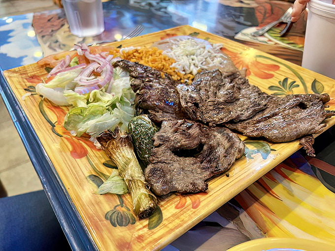 Carne asada doesn't get more honest than this—perfectly charred beef served with grilled green onions on a wooden platter that's dressed to impress.
