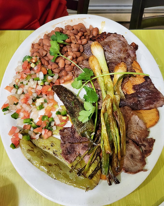 This isn't just steak &ndash; it's a carnivore's dream team. Grilled green onions, beans, pico de gallo, and that perfectly charred cactus paddle create a flavor symphony.