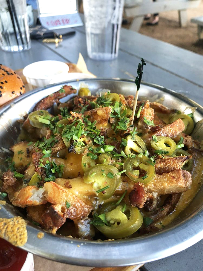 The cheese-to-fry ratio here deserves scientific study. Like a yellow lava flow cascading over potato mountains, creating bite-sized moments of perfection.