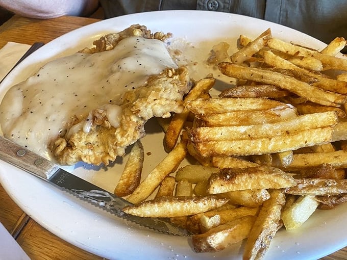Country-fried steak smothered in peppery gravy alongside golden fries&mdash;the kind of plate that makes you want to hug the cook afterward.