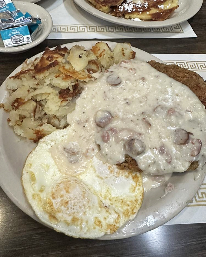 Chicken fried steak smothered in creamy country gravy &ndash; the kind of hearty breakfast that fueled generations before "brunch" became a verb.