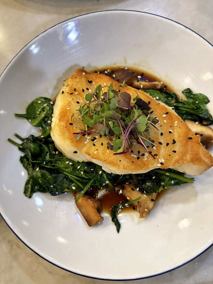 Perfectly seared Chilean sea bass resting on a bed of greens&mdash;proof that sometimes the simplest preparations yield the most elegant results.