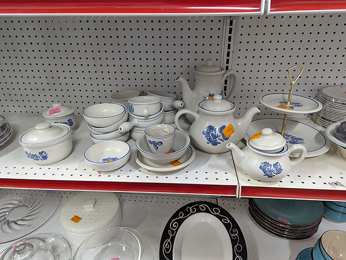 Delicate blue and white china waits patiently on metal shelves, dreaming of hosting dinner parties more elegant than their price tags suggest.