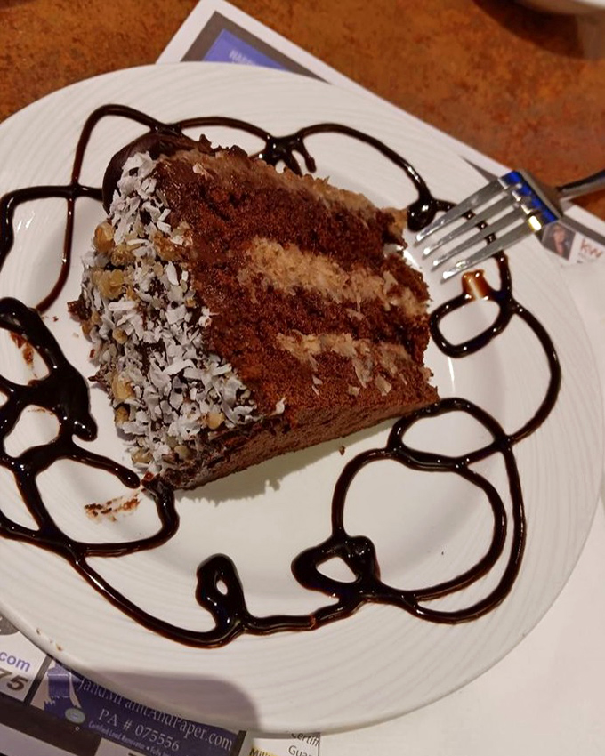 Behold the chocolate cake that launched a thousand road trips &ndash; layers of cocoa perfection adorned with coconut and chocolate drizzle.