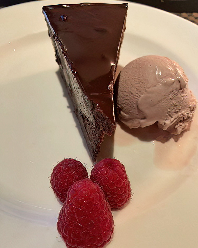 This chocolate masterpiece towers with decadent layers, making dessert decisions feel less like choices and more like destiny calling.