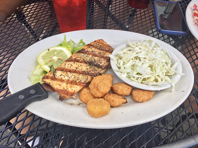 Grilled salmon that's dressed for success, flanked by golden nuggets of fried goodness and a coleslaw that means business.