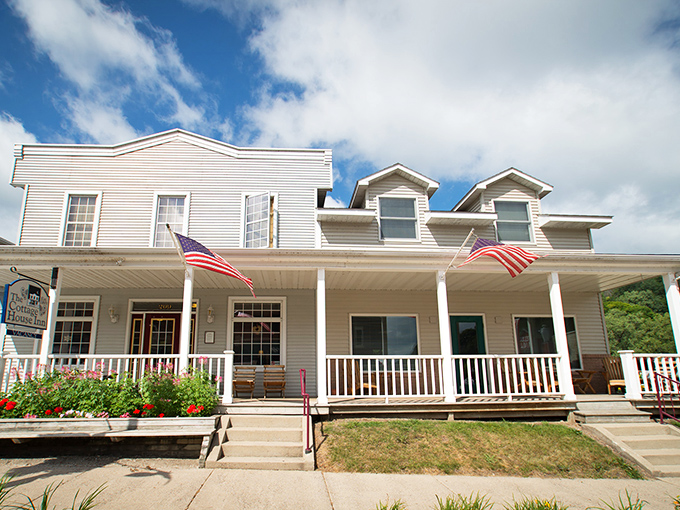 The Cottage House Inn's porch practically begs you to sit with morning coffee, watching the town wake up beneath those American flags.