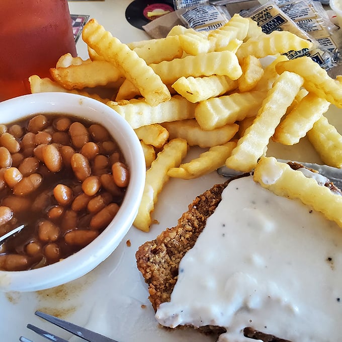 Country fried steak with a side of nostalgia. Those crinkle-cut fries and beans aren't just sides&mdash;they're essential characters in this comfort food story.