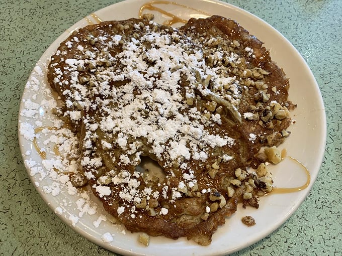 The croissant French toast arrives like breakfast royalty – golden, powdered, and ready to make your ordinary morning extraordinary.