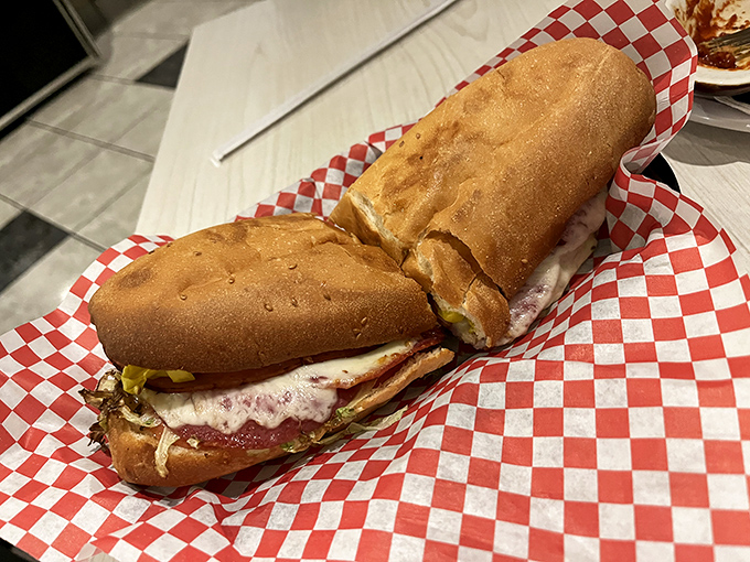 This isn't just a sandwich; it's a skyscraper of flavors tucked between fresh bread, served on classic red-checkered paper that signals deliciousness ahead.