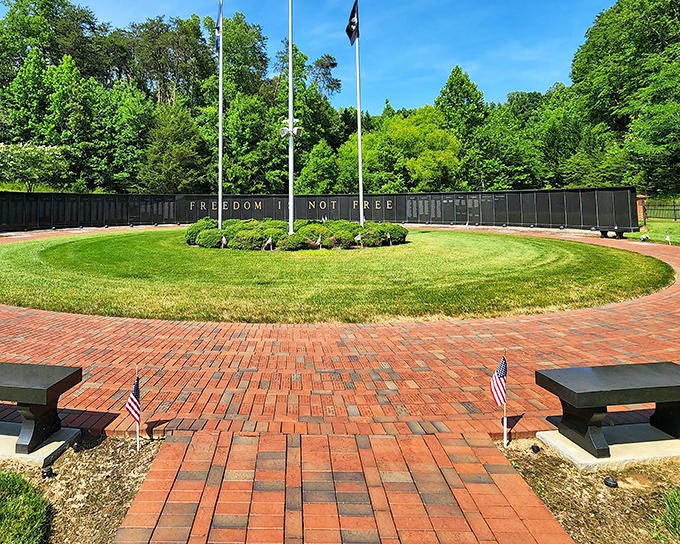 "Freedom is not free" reads this solemn memorial, where brick pathways and carefully placed flags honor those who served with quiet dignity.