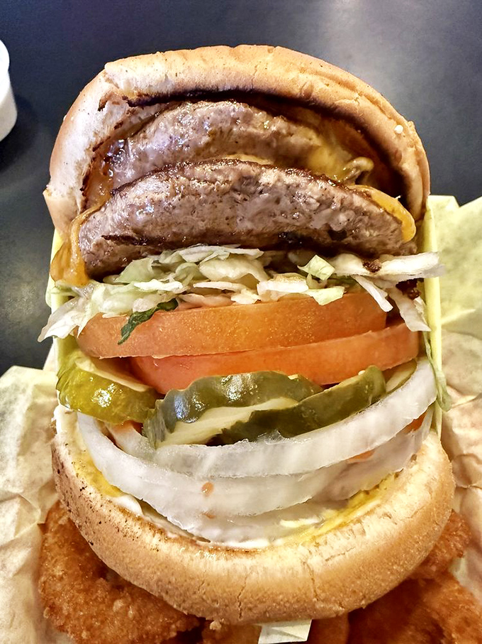 Behold the double cheeseburger in its natural habitat &ndash; a towering monument to excess that somehow maintains perfect structural integrity with each glorious bite.