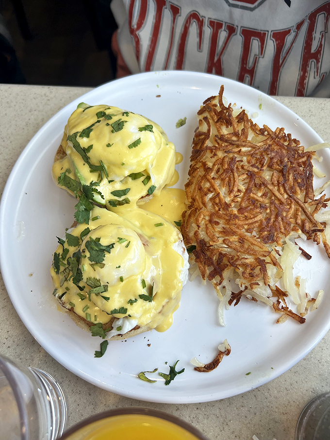 Eggs Benedict done right is culinary poetry—these golden orbs of hollandaise-draped perfection sitting atop crispy hashbrowns might bring a tear to your eye.