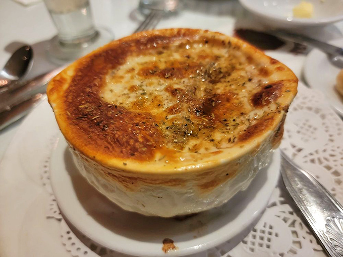 French onion soup done right &ndash; that golden, bubbling cheese top hiding a savory broth beneath is like the culinary equivalent of finding hidden treasure.