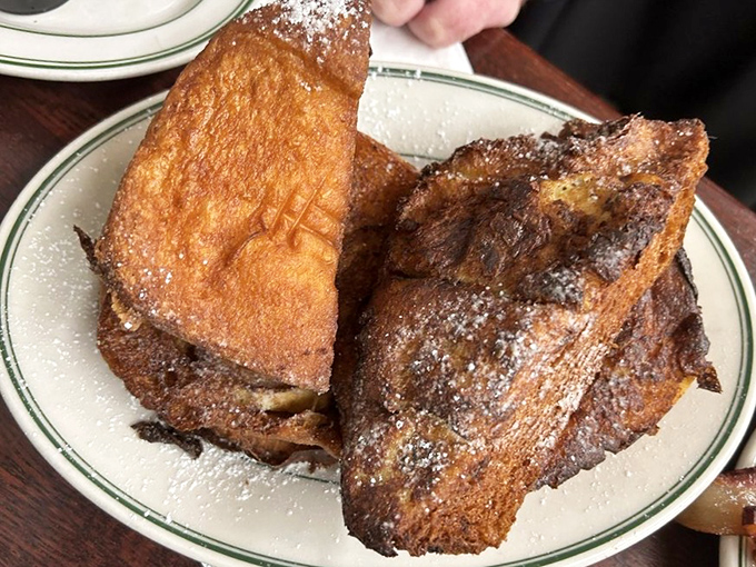 This isn't French toast; it's what French toast dreams of becoming when it grows up – crispy edges, custardy centers, and a snowfall of powdered sugar.