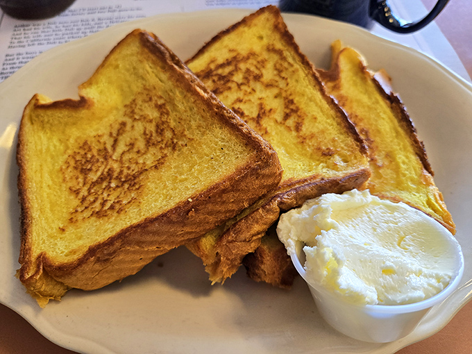 Golden challah French toast that would make your grandmother weep with joy. The butter melts into every nook, creating breakfast perfection.