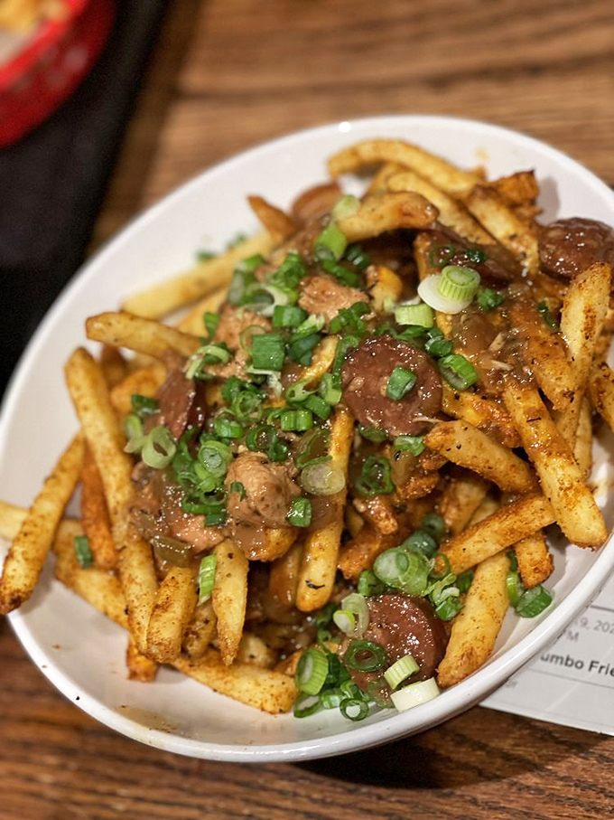 Poutine perfection! Gravy cascading over crispy fries with green onions adding that perfect pop of color and freshness.