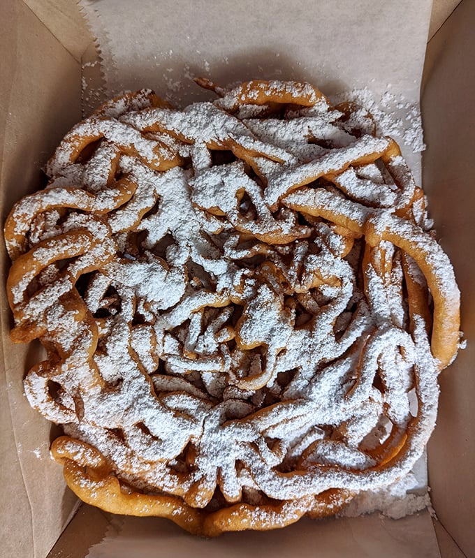A funnel cake snowstorm of powdered sugar that would make any state fair jealous. Crispy, golden, and utterly irresistible.