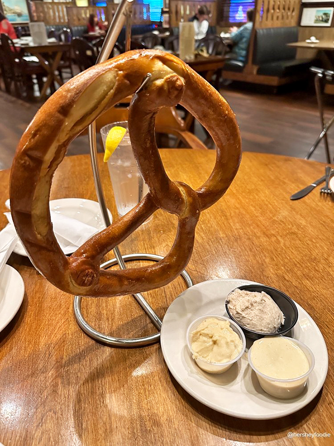 The famous pretzel arrives like edible architecture&mdash;hanging majestically on its custom stand with dipping sauces standing by for dunking duty.