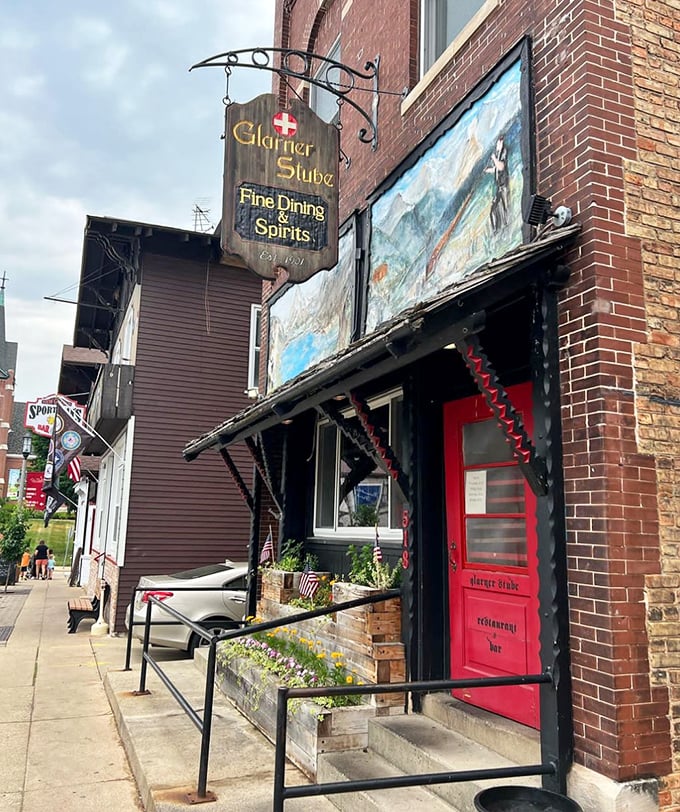 Glarner Stube's inviting red door practically whispers "come in" to passersby, promising authentic Swiss cuisine and Alpine hospitality inside.