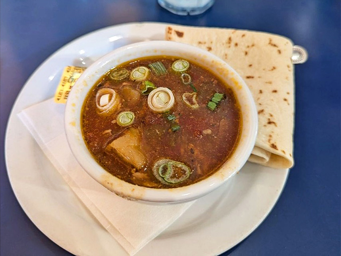 Green Chile Stew that looks like it could cure whatever ails you &ndash; served with a tortilla that's practically begging to dive into that flavorful broth.