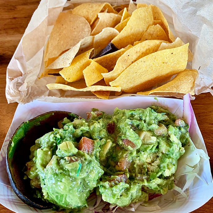 Fresh guacamole that practically screams "I was an avocado this morning!" Chunky, vibrant, and demanding to be scooped up by those golden chips.