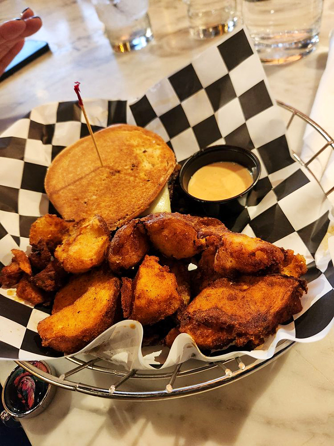 Comfort food diplomacy in action&mdash;this basket of golden-brown delights, served with a creamy dipping sauce, exemplifies the diner's commitment to happiness through carbohydrates.