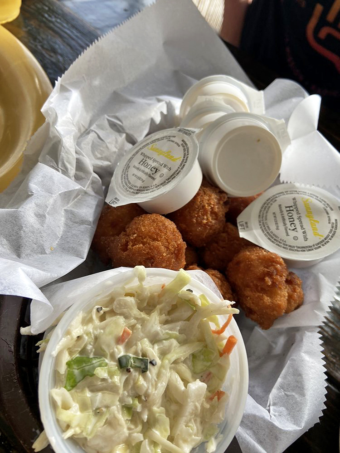 Hushpuppies that would make your Southern grandmother nod in approval, paired with coleslaw that cuts through the richness perfectly.