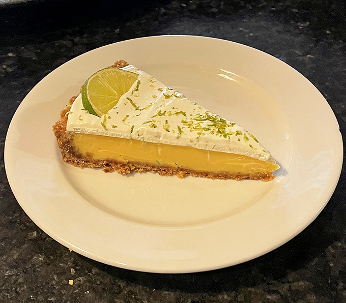 Key lime pie that hits the perfect tart-sweet balance, topped with a lime slice that's both garnish and gentle warning of the zing ahead.