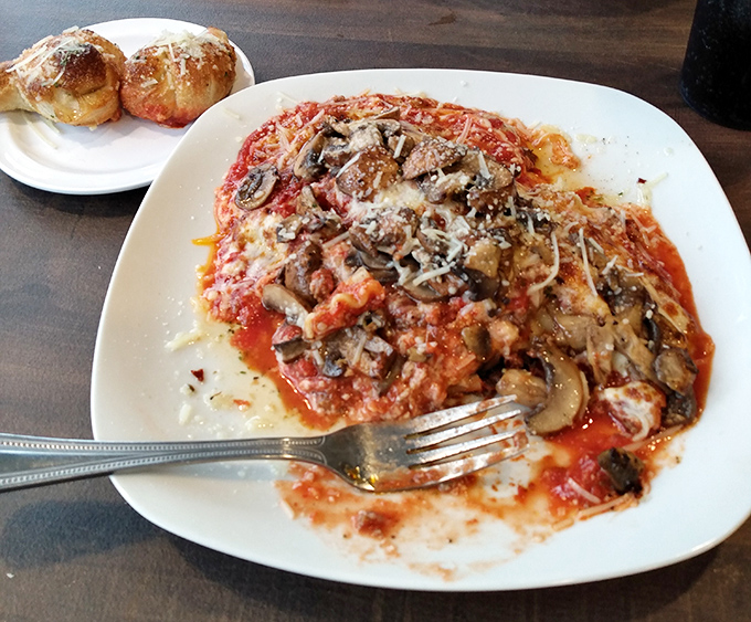 Layers of pasta, cheese, and mushrooms meld together in this hearty Italian classic. Those garlic knots on the side? The perfect sauce-sopping companions.