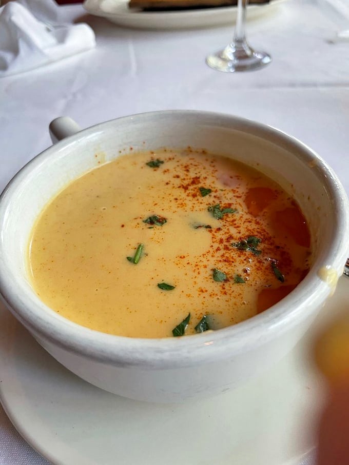 This lobster bisque isn't just soup; it's a velvety orange sea of happiness that makes you wonder why you'd ever order anything else.