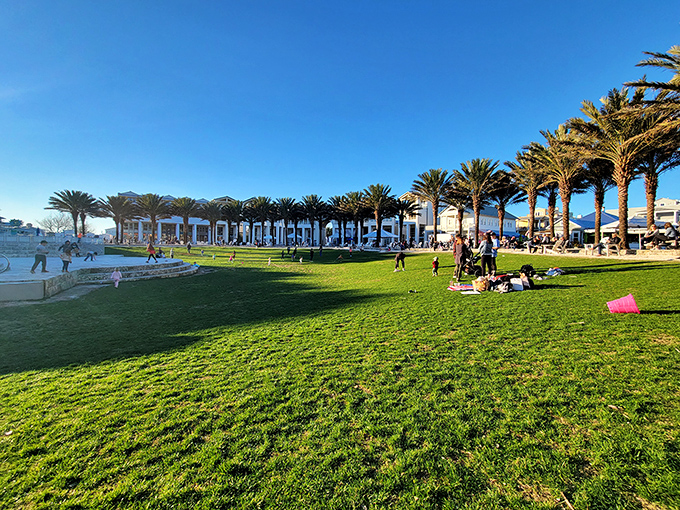 The town green serves as Seaside's living room, where palm trees provide natural air conditioning and families create memories on a canvas of perfect grass.