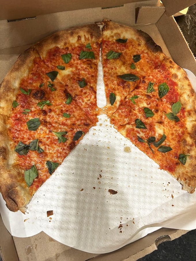 Fresh basil scattered like confetti over molten cheese and bright tomato sauce. This pizza doesn't need a passport to transport you to Italy.