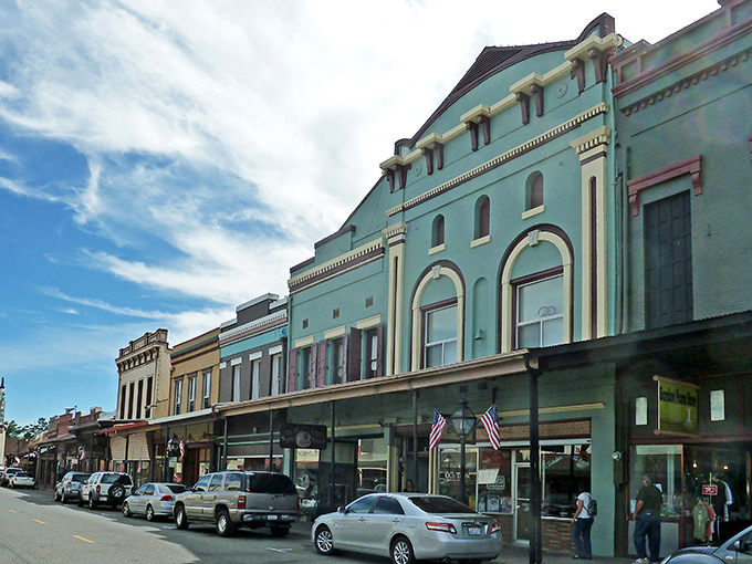 Mill Street's pastel-colored buildings house local businesses where shop owners still remember your name and your coffee order without needing an app.