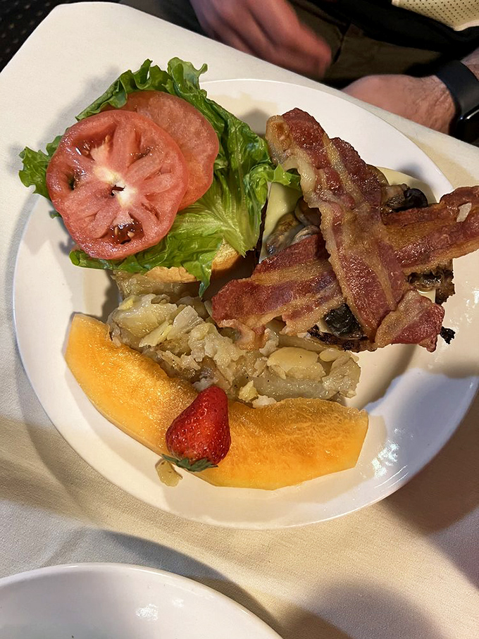 Layer upon delicious layer! This burger's architectural achievement of bacon, cheese, and fresh toppings deserves its own station on the flavor express.