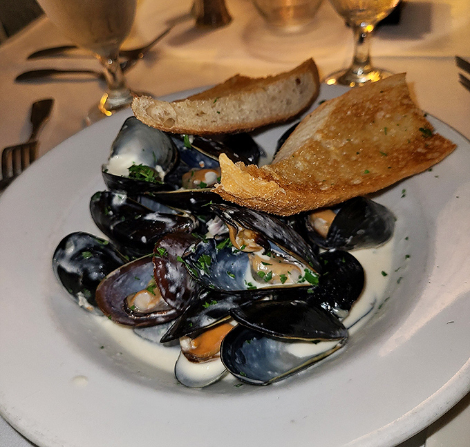 These mussels aren't just swimming in sauce—they're doing the backstroke in a pool of garlicky, buttery heaven worth every bit of bread-sopping.