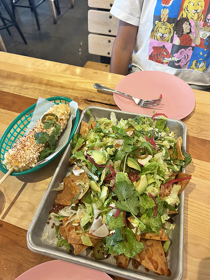 The ultimate table spread: garden-fresh nachos alongside elote that's been dressed for success. Mexican street food elevated to art form.