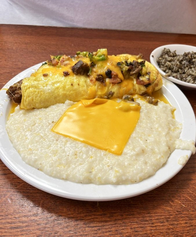 This omelet doesn't just sit on the plate&mdash;it commands attention. Melted cheese cascades over fluffy eggs while grits stand by, ready for their moment.