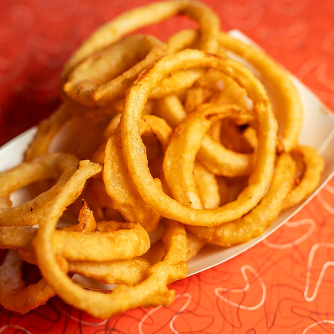 Onion rings that could double as jewelry. These golden halos of happiness shatter with a satisfying crunch that'll have you ordering seconds before finishing firsts.