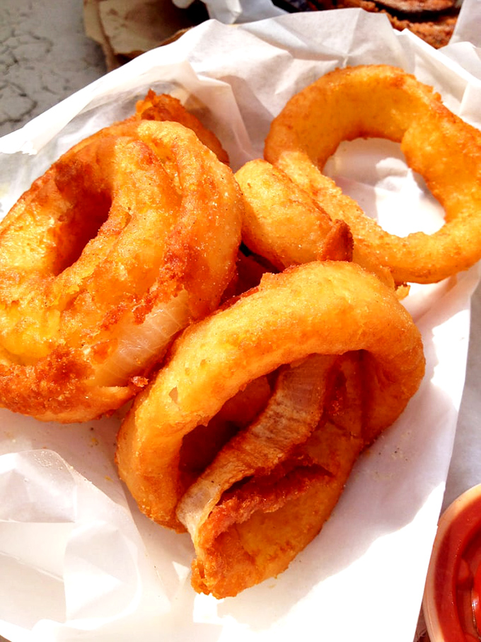 These aren't just onion rings; they're golden halos of happiness that crunch loud enough to drown out your diet's protests.
