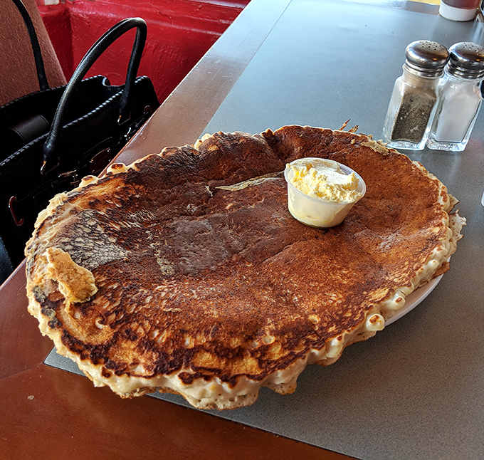 The pancake that ate Wickenburg! This golden-brown behemoth doesn't just hang over the edge of the plate&mdash;it conquers it completely.