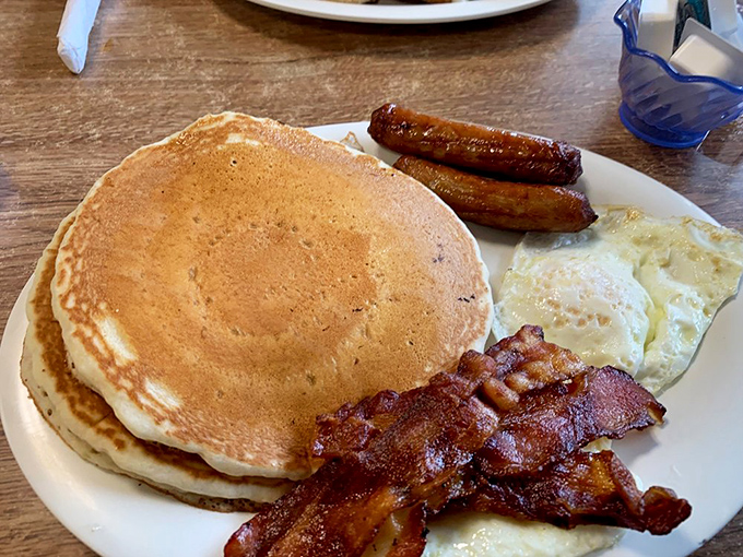 Pancakes so perfectly golden they deserve their own sunrise, paired with eggs and meat that make waking up worthwhile.