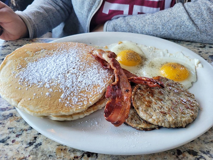 Pancakes dusted with powdered sugar, eggs with perfect sunny centers, and bacon that's achieved crispy nirvana. The breakfast trinity in its highest form.