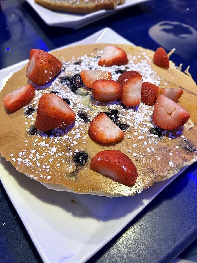 Pancakes that don't just sit on the plate—they perform! Fresh strawberries and a dusting of powdered sugar turn breakfast into an edible art form.