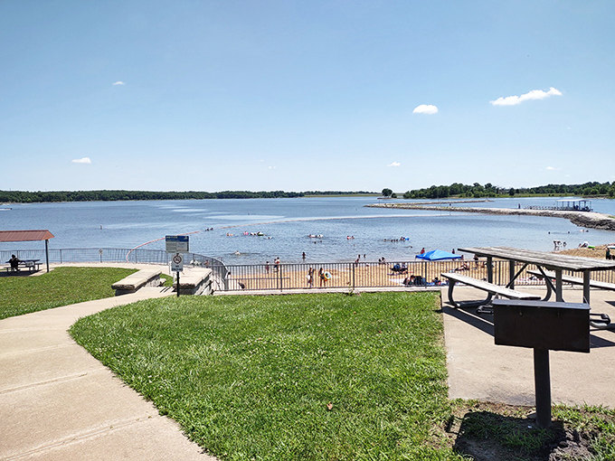 Beach day infrastructure done right. Grassy knolls, picnic spots, and that inviting water just steps away. No beach umbrella wrestling required.