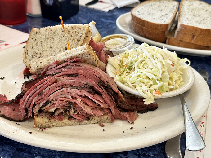 When your sandwich requires structural engineering rather than recipe development. The coleslaw side dish looks like it's trying to maintain a safe distance.