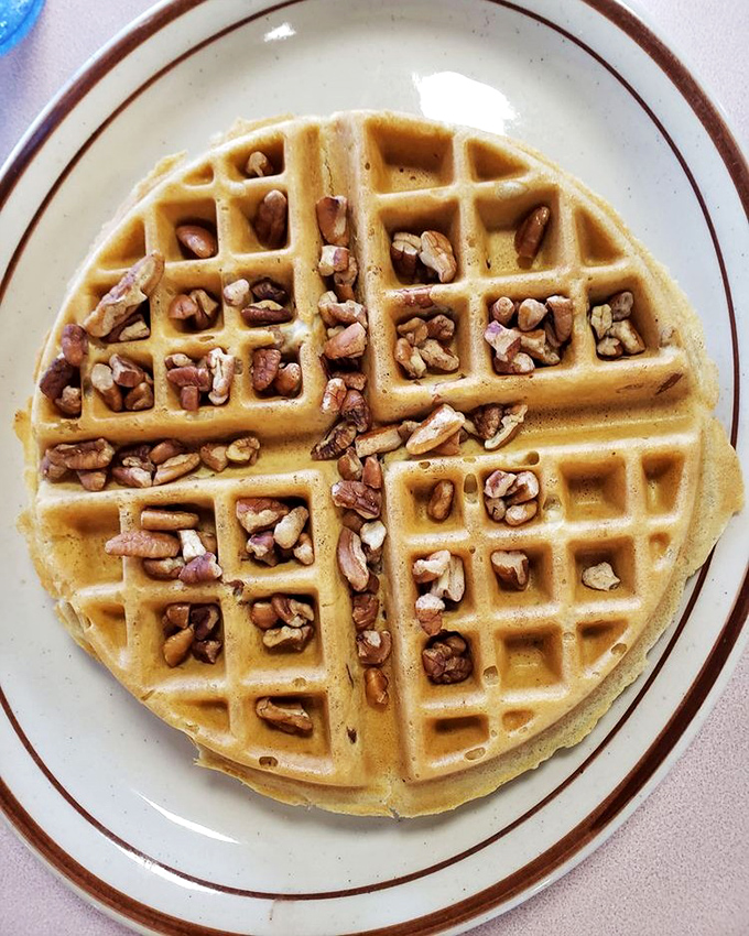 The Belgian waffle's deep pockets cradle pecans like nature's treasure chests, ready to be discovered with each bite.