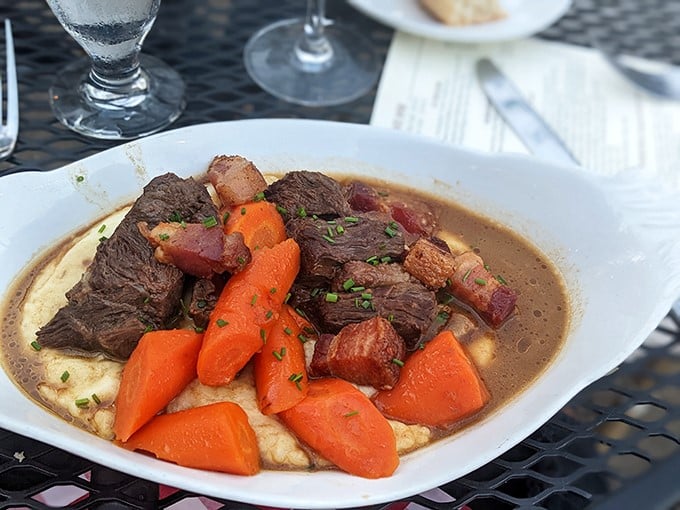 This isn't just pot roast; it's beef bourguignon's sophisticated cousin taking a luxurious bath in rich jus over creamy polenta.