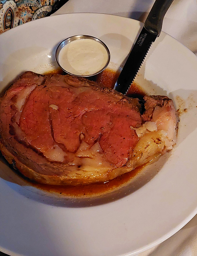 The legendary prime rib arrives in all its glory, a rosy masterpiece that explains why seafood lovers sometimes forget about the ocean.